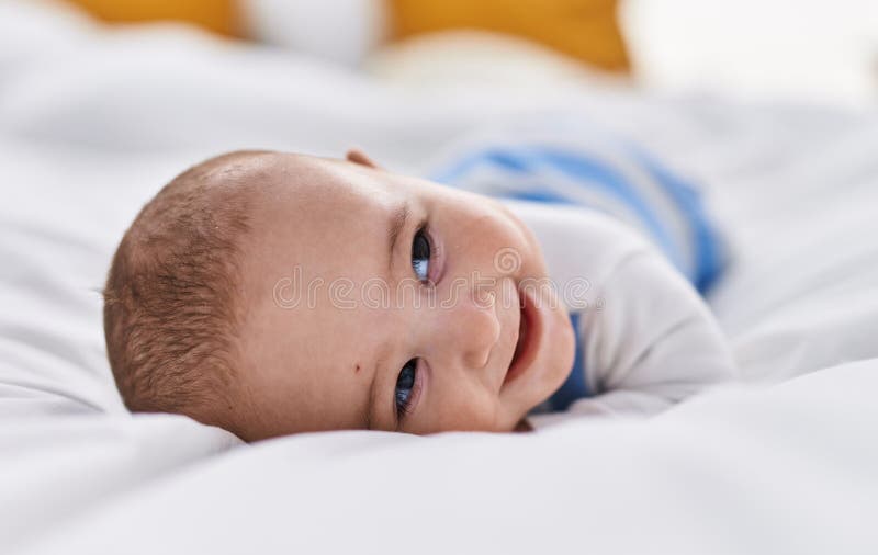 Adorable Baby Smiling Confident Lying on Bed at Bedroom Stock Photo ...