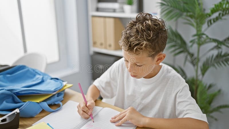 Adorable Blond Boy Student Concentrating and Taking Notes at His Desk ...