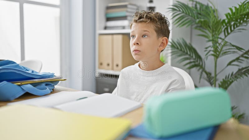 Adorable Blond Boy Student, Focused on His Studies, Sitting Seriously ...