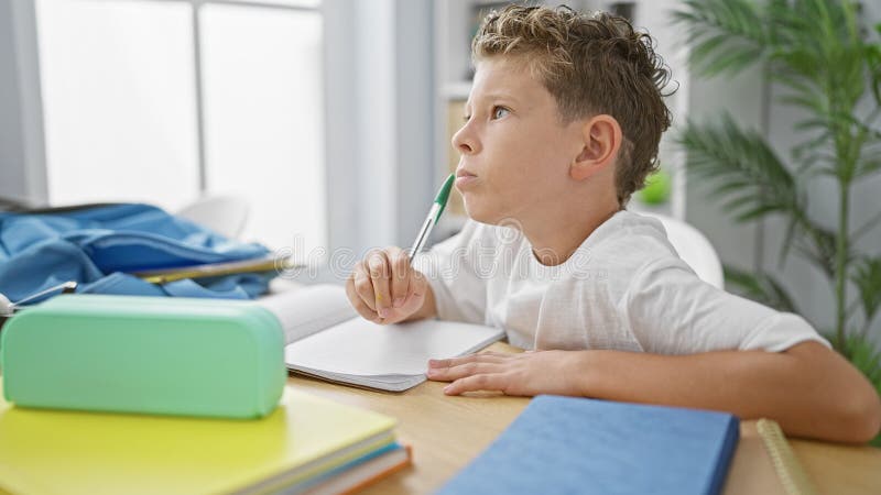 Adorable Blond Boy Student, Focused on Learning, Taking Notes Sitting ...