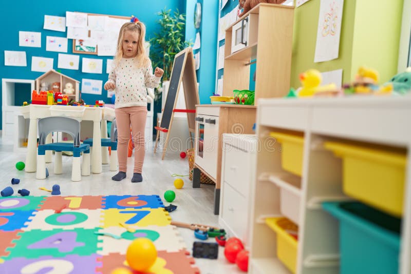 Adorable Blonde Girl Standing with Relaxed Expression at Kindergarten ...