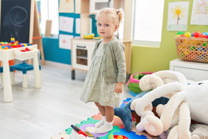 Adorable Blonde Girl Standing with Relaxed Expression at Kindergarten ...
