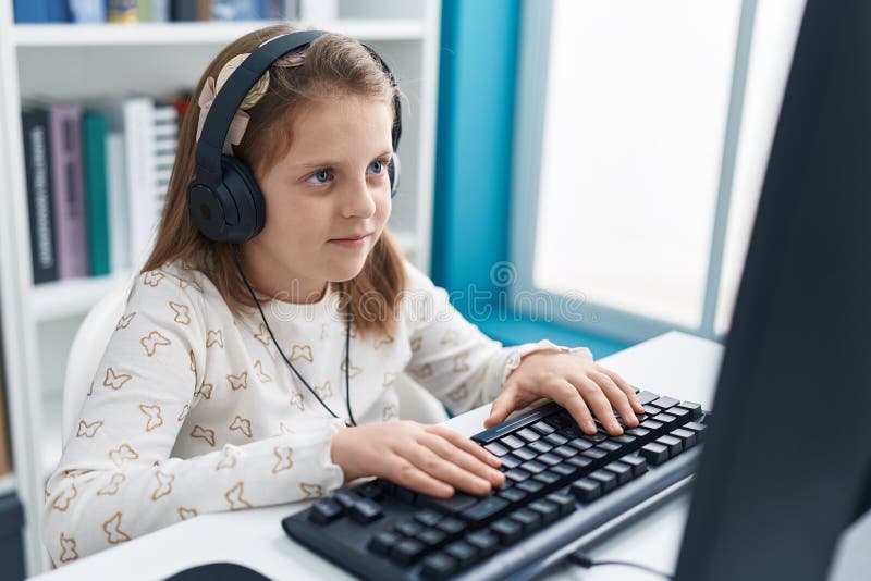 Adorable Blonde Girl Student Using Computer and Headphones Studying at ...