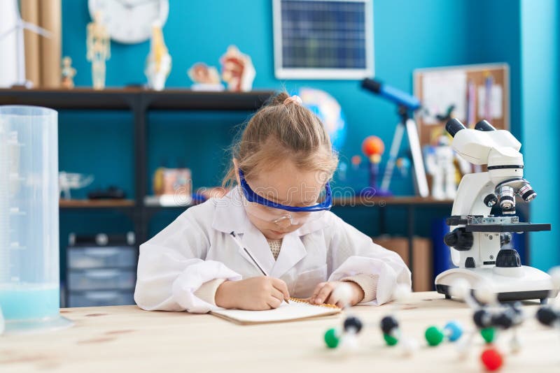 Adorable Blonde Girl Student Using Microscope Writing on Notebook at ...
