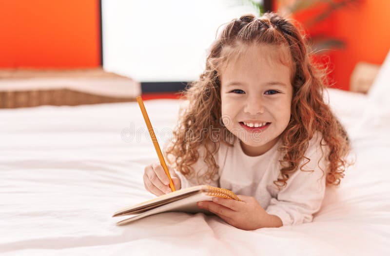 Adorable Blonde Toddler Writing on Notebook Lying on Bed at Bedroom ...
