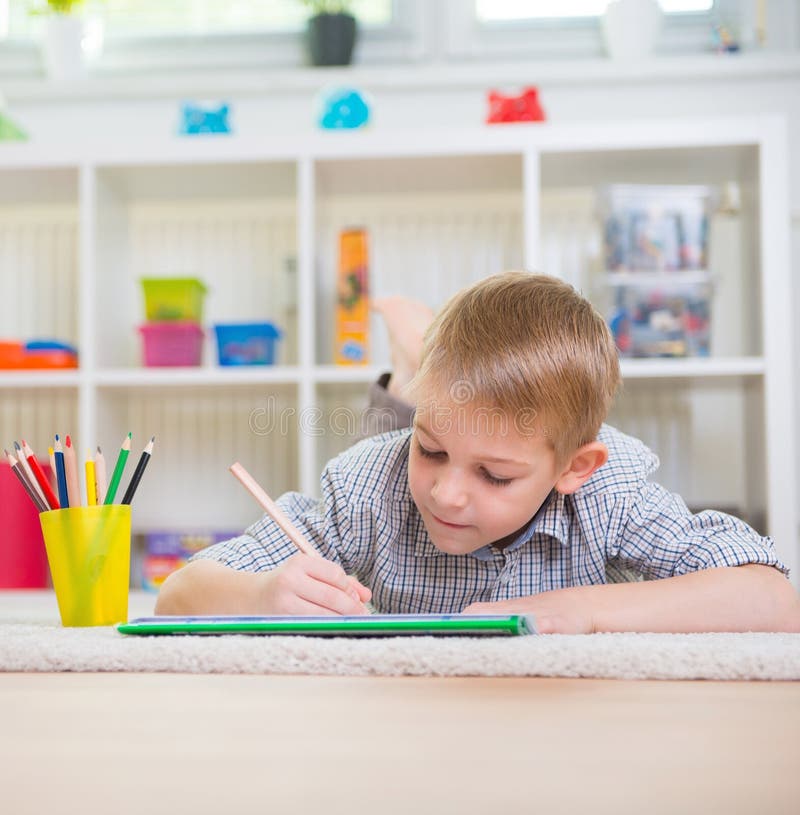 Adorable boy draws at home stock photo. Image of development - 60074778