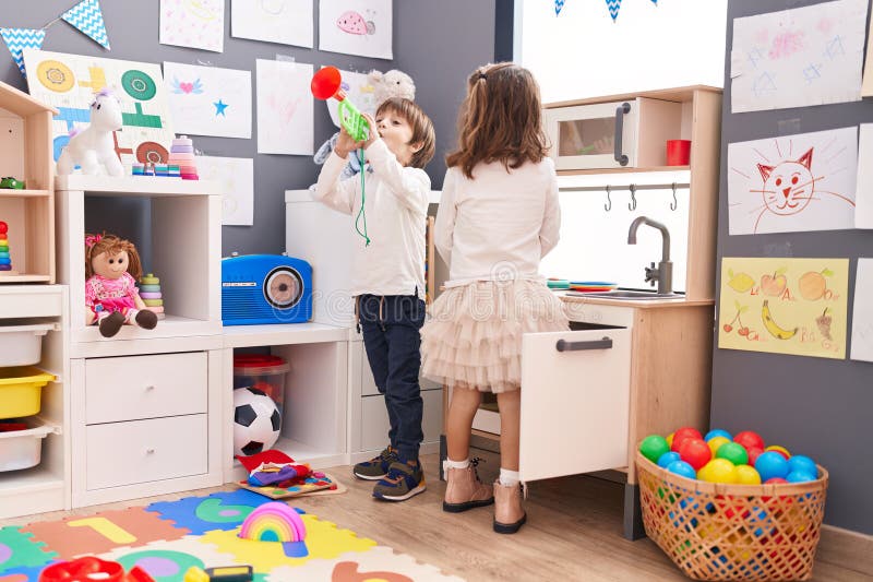 Adorable Boy and Girl Playing with Play Kitchen Using Trumpet at ...