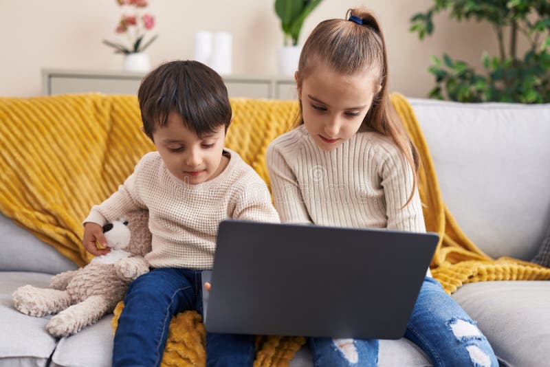 Adorable Boy and Girl Using Laptop Sitting on Sofa at Home Stock Photo ...
