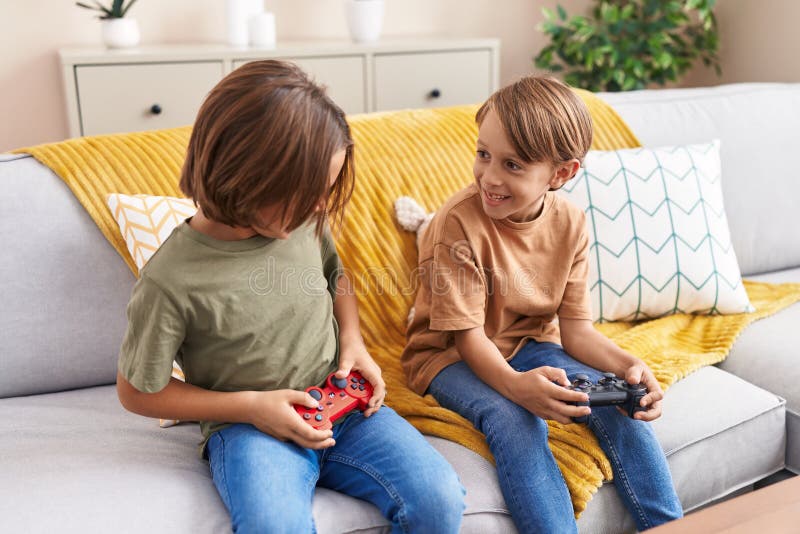 Adorable Boys Playing Video Game Sitting on Sofa at Home Stock Photo ...