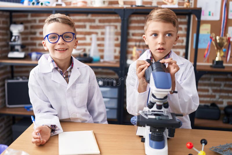 Adorable Boys Students Using Microscope Writing Notes at Laboratory ...