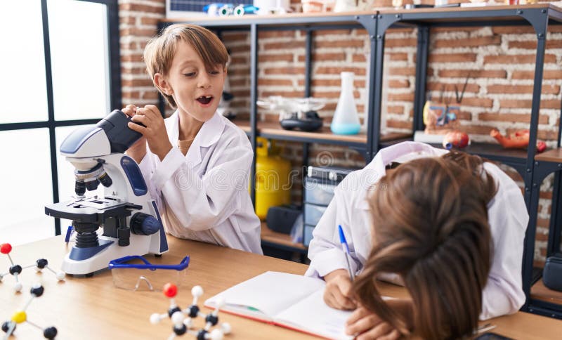 Adorable Boys Students Using Microscope Writing Notes at Laboratory ...