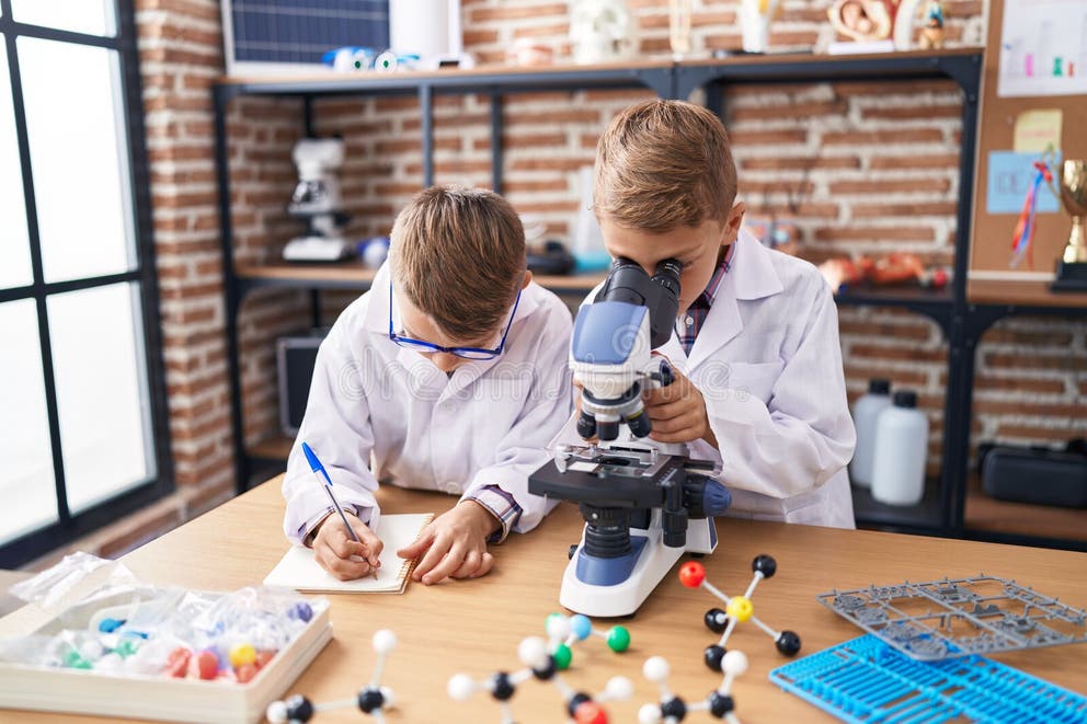 Adorable Boys Students Using Microscope Writing Notes at Laboratory ...