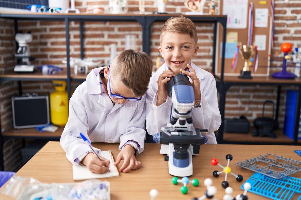 Adorable Boys Students Using Microscope Writing Notes at Laboratory ...
