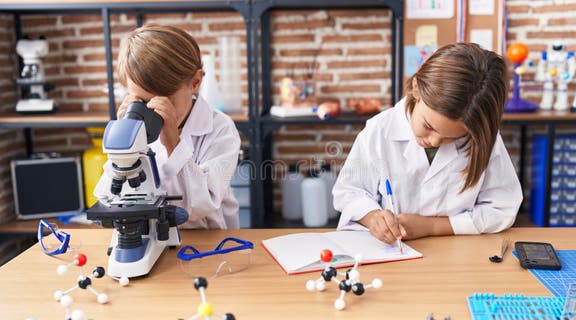 Adorable Boys Students Using Microscope Writing Notes at Laboratory ...