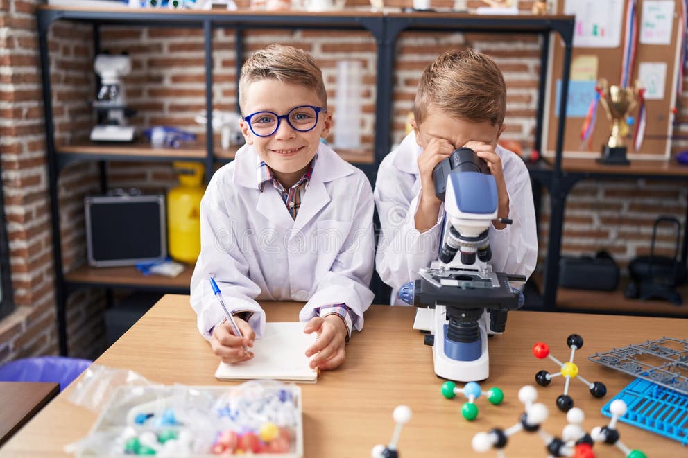 Adorable Boys Students Using Microscope Writing Notes at Laboratory ...