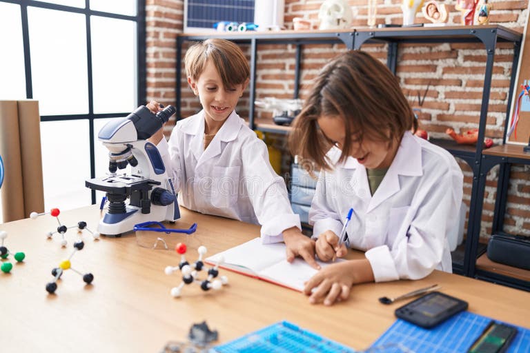 Adorable Boys Students Using Microscope Writing Notes at Laboratory ...
