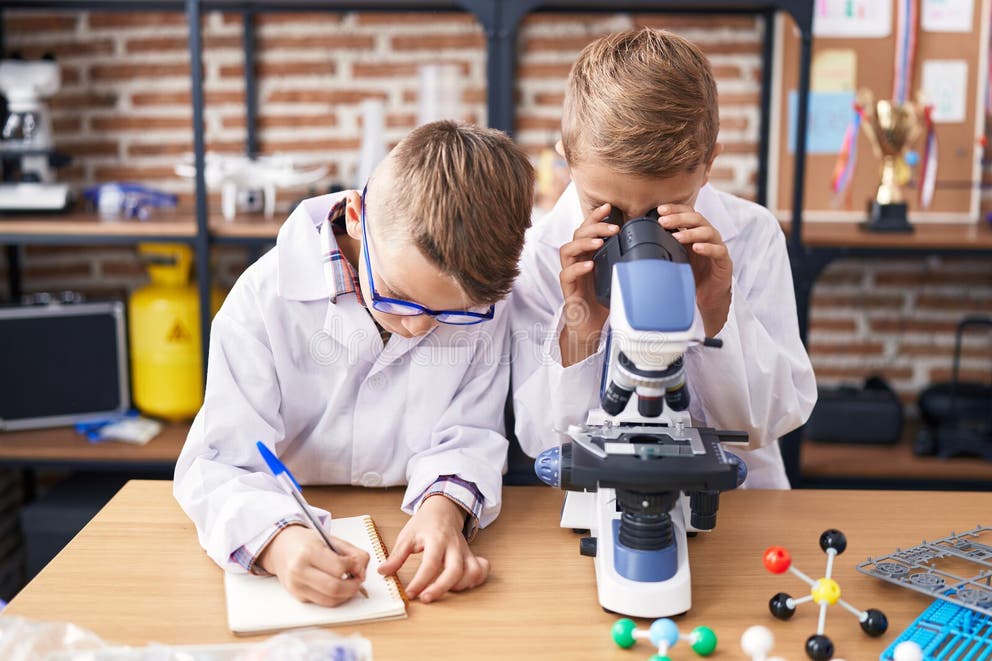 Adorable Boys Students Using Microscope Writing Notes at Laboratory ...