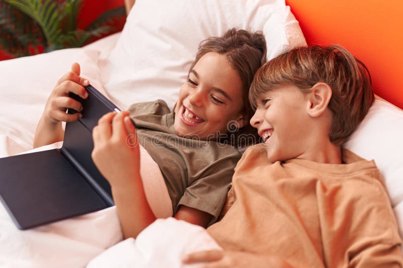 Adorable Boys Using Touchpad Lying on Bed at Bedroom Stock Image ...