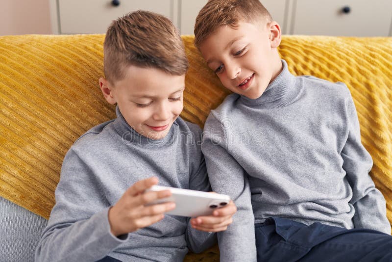 Adorable Boys Watching Video on Smartphone Sitting on Sofa at Home ...