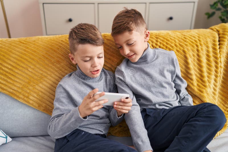 Adorable Boys Watching Video on Smartphone Sitting on Sofa at Home ...