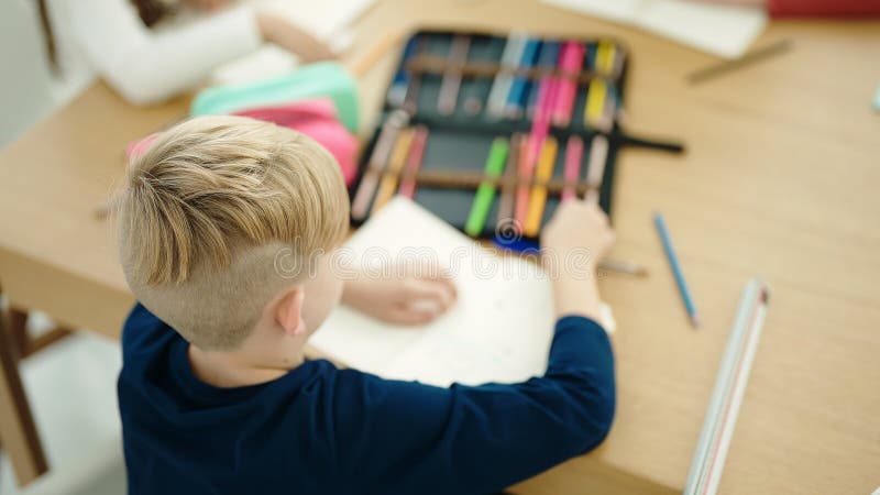 Adorable Caucasian Boy Student Drawing on Notebook Sitting on Table at ...
