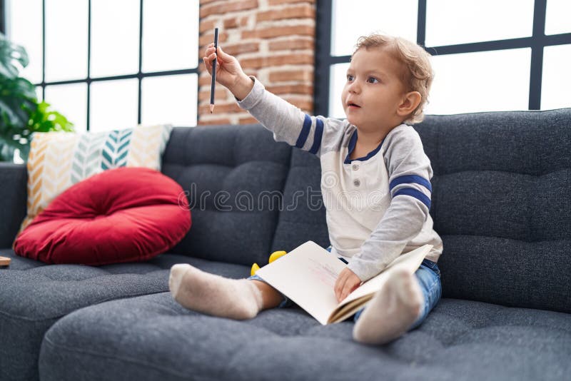 Adorable Caucasian Boy Student Sitting on Sofa Drawing on Notebook at ...