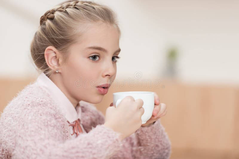 Adorable Child Blowing on Coffee in Cup while Sitting Stock Photo ...