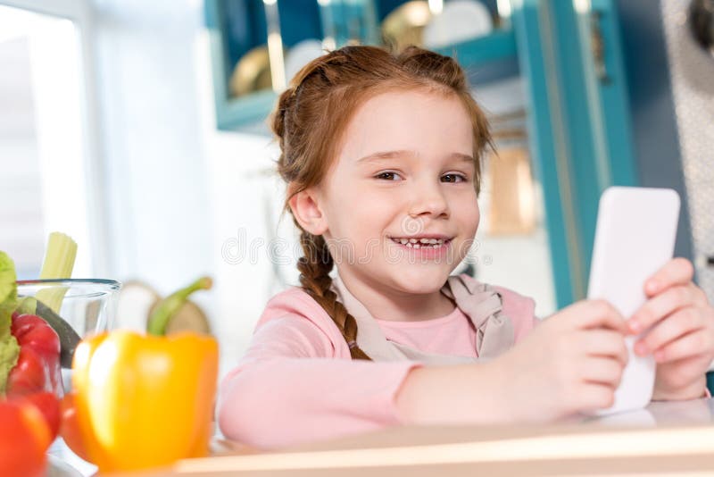 Adorable Child Smiling at Camera while Using Smartphone Stock Image ...
