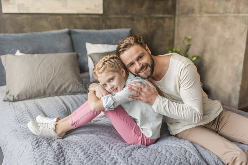 Adorable Daughter and Father Sitting on Bed at Home Stock Image - Image ...