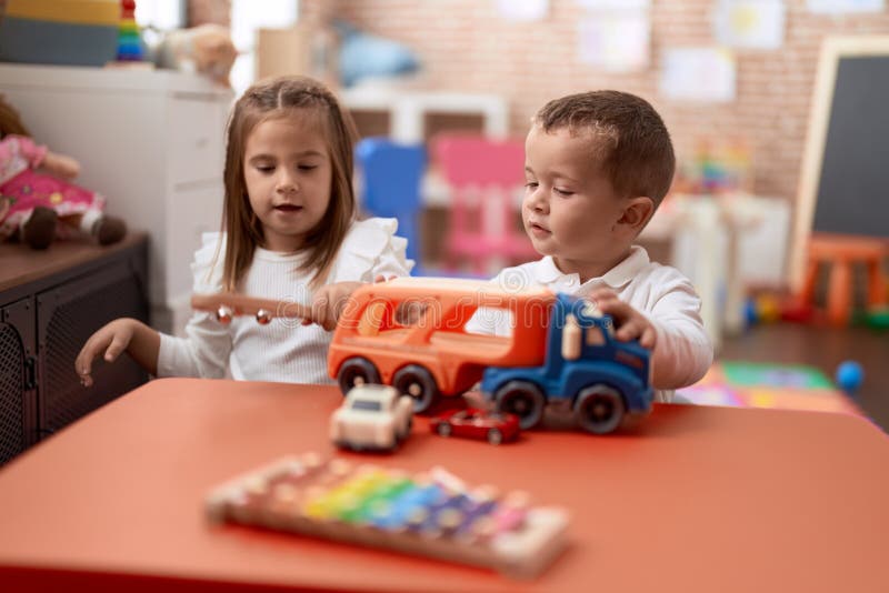 Adorable Girl and Boy Playing with Car on Table at Kindergarten Stock ...