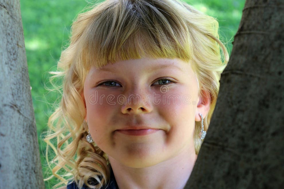 Adorable Girl Smiling through Tree Branches Stock Image - Image of ...