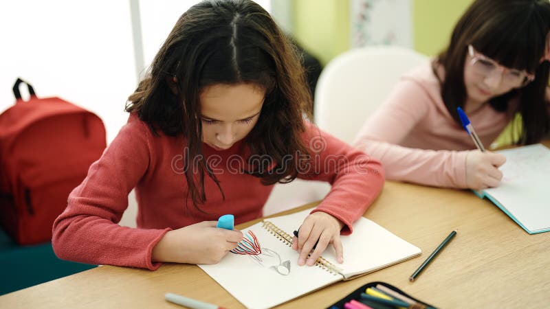 Adorable Girls Students Sitting on Table Drawing on Notebook at ...