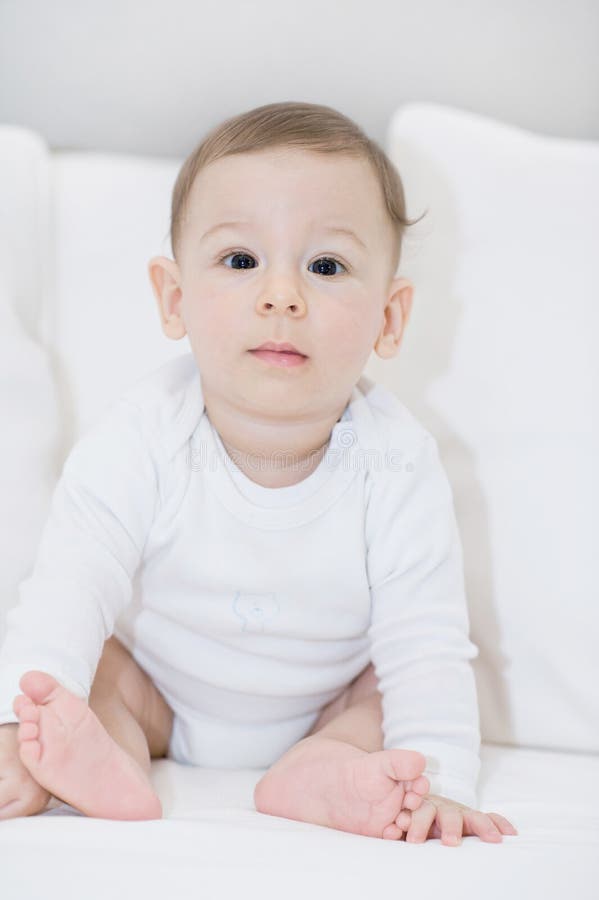 An Adorable, Happy Baby Looking at Camera on White Pillows Stock Photo ...