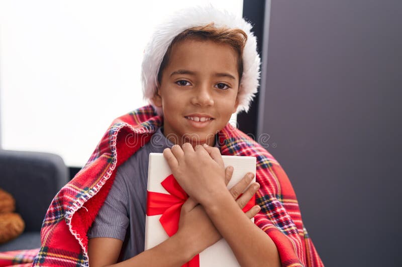 Adorable Hispanic Boy Hugging Christmas Gift Standing at Home Stock ...