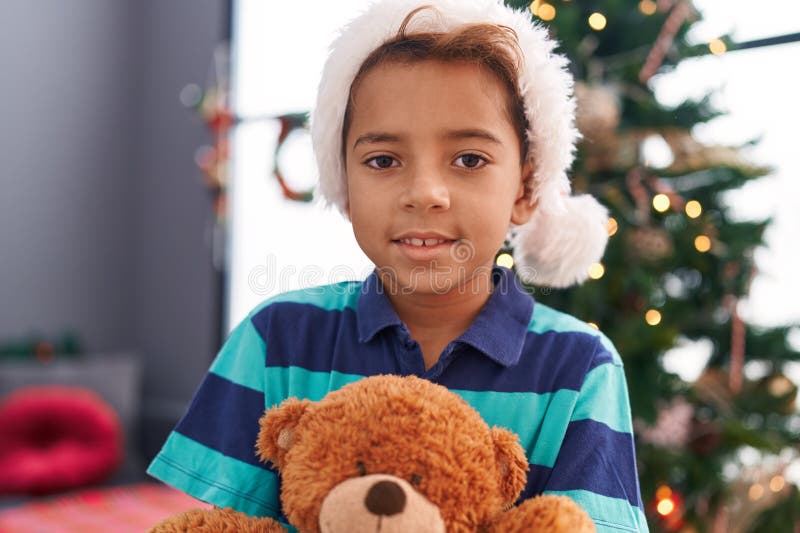 Adorable Hispanic Boy Hugging Teddy Bear Standing by Christmas Tree at ...