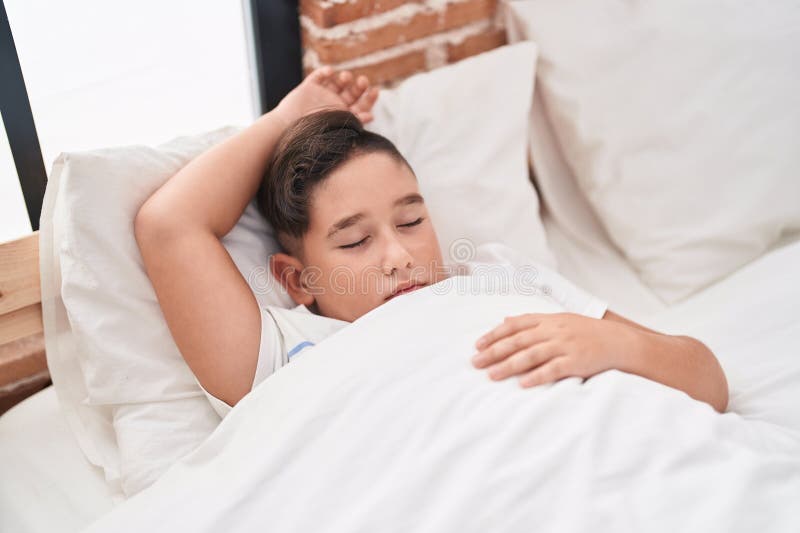 Adorable Hispanic Boy Lying on Bed Sleeping at Bedroom Stock Photo ...