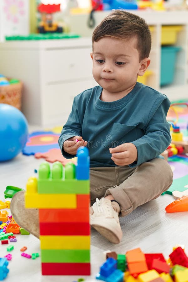 Adorable Hispanic Boy Playing with Construction Blocks Sitting on Floor ...