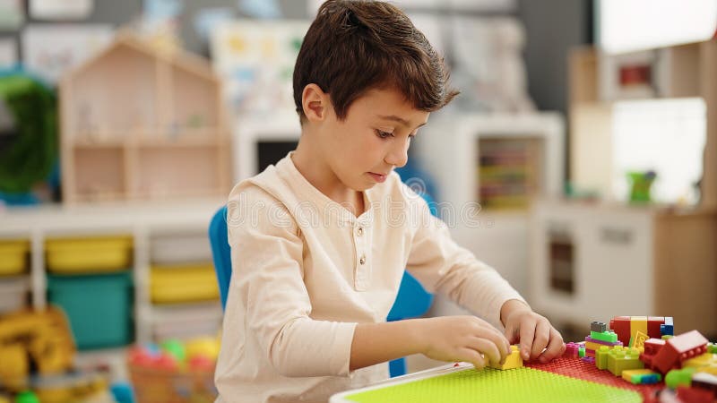 Adorable Hispanic Boy Playing with Construction Blocks Sitting on Table ...