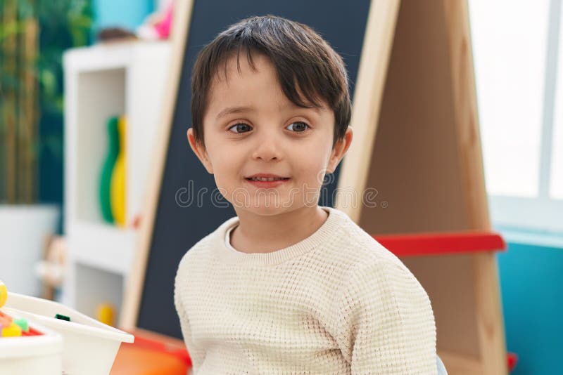Adorable Hispanic Boy Playing with Construction Blocks Sitting on Table ...