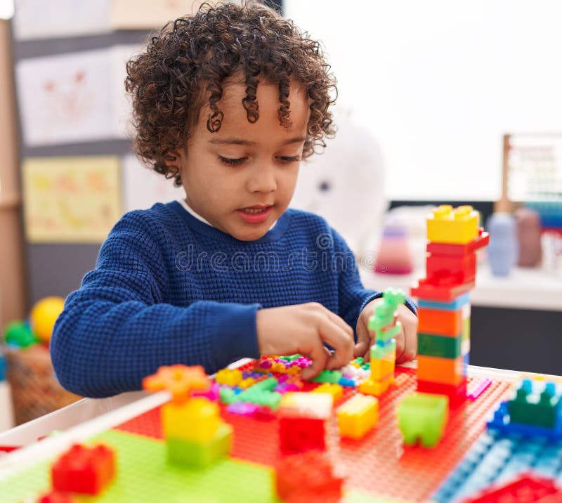 Adorable Hispanic Boy Playing with Construction Blocks Sitting on Table ...