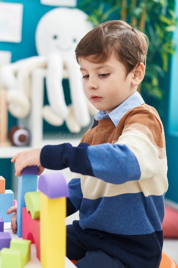 Adorable Hispanic Boy Playing with Construction Blocks Sitting on Table ...