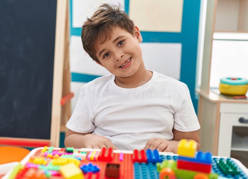 Adorable Hispanic Boy Playing with Construction Blocks Sitting on Table ...