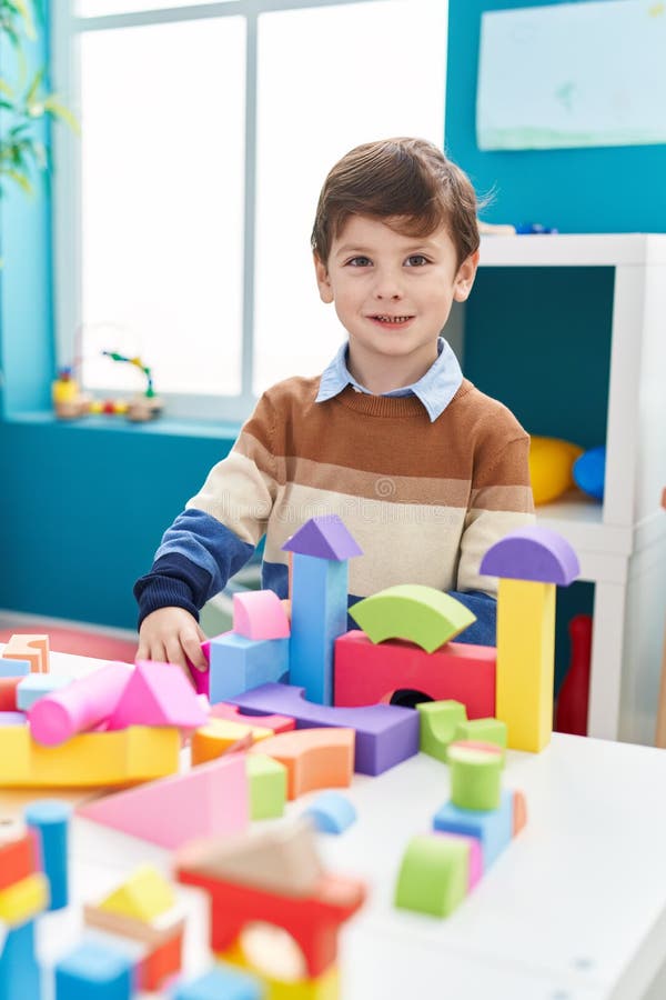 Adorable Hispanic Boy Playing with Construction Blocks Standing at ...