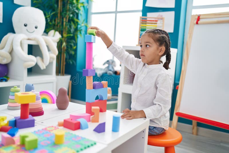 Adorable Hispanic Boy Playing with Construction Blocks Standing at ...