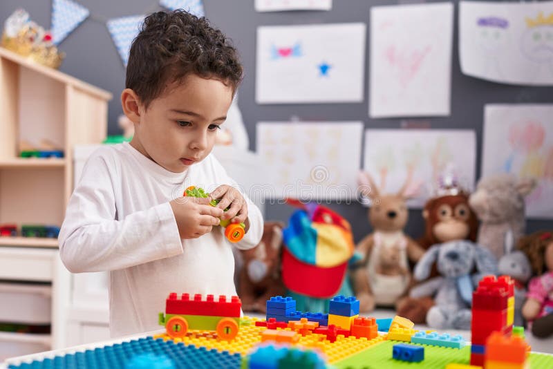 Adorable Hispanic Boy Playing with Construction Blocks Standing at ...