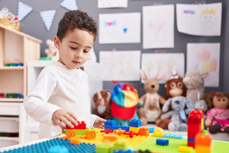 Adorable Hispanic Boy Playing with Construction Blocks Standing at ...