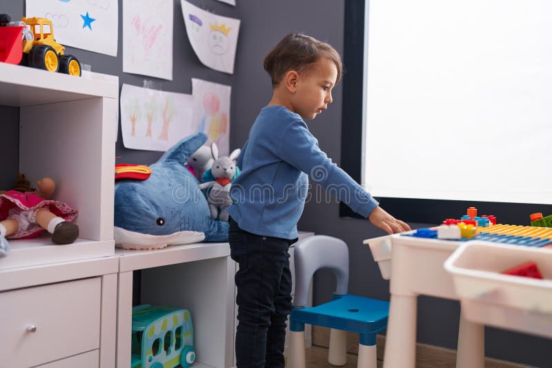 Adorable Hispanic Boy Playing with Construction Blocks Standing at ...