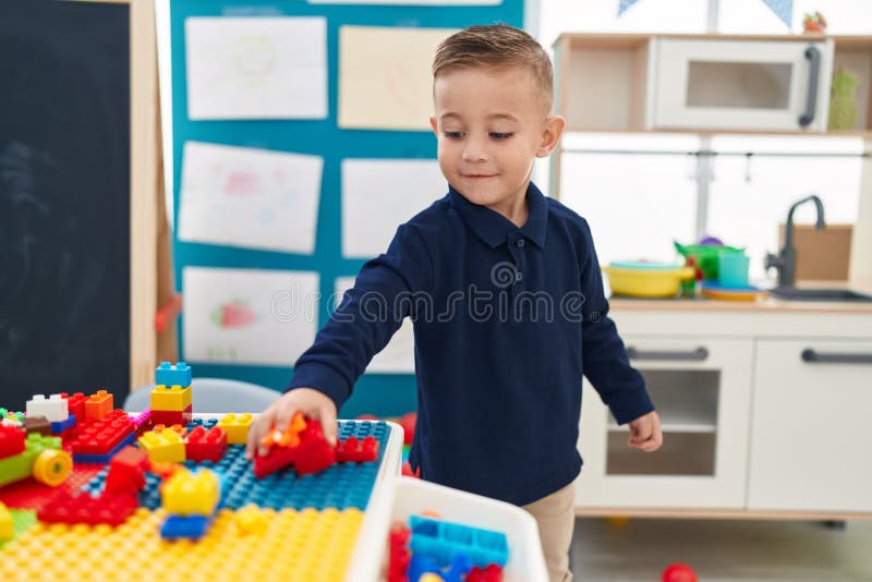 Adorable Hispanic Boy Playing with Construction Blocks Standing at ...