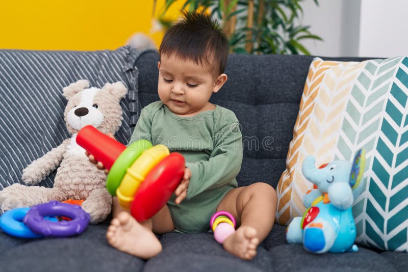 Adorable Hispanic Boy Playing with Hoops Game Sitting on Sofa at Home ...
