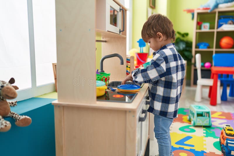 Adorable Hispanic Boy Playing with Play Kitchen Standing at ...